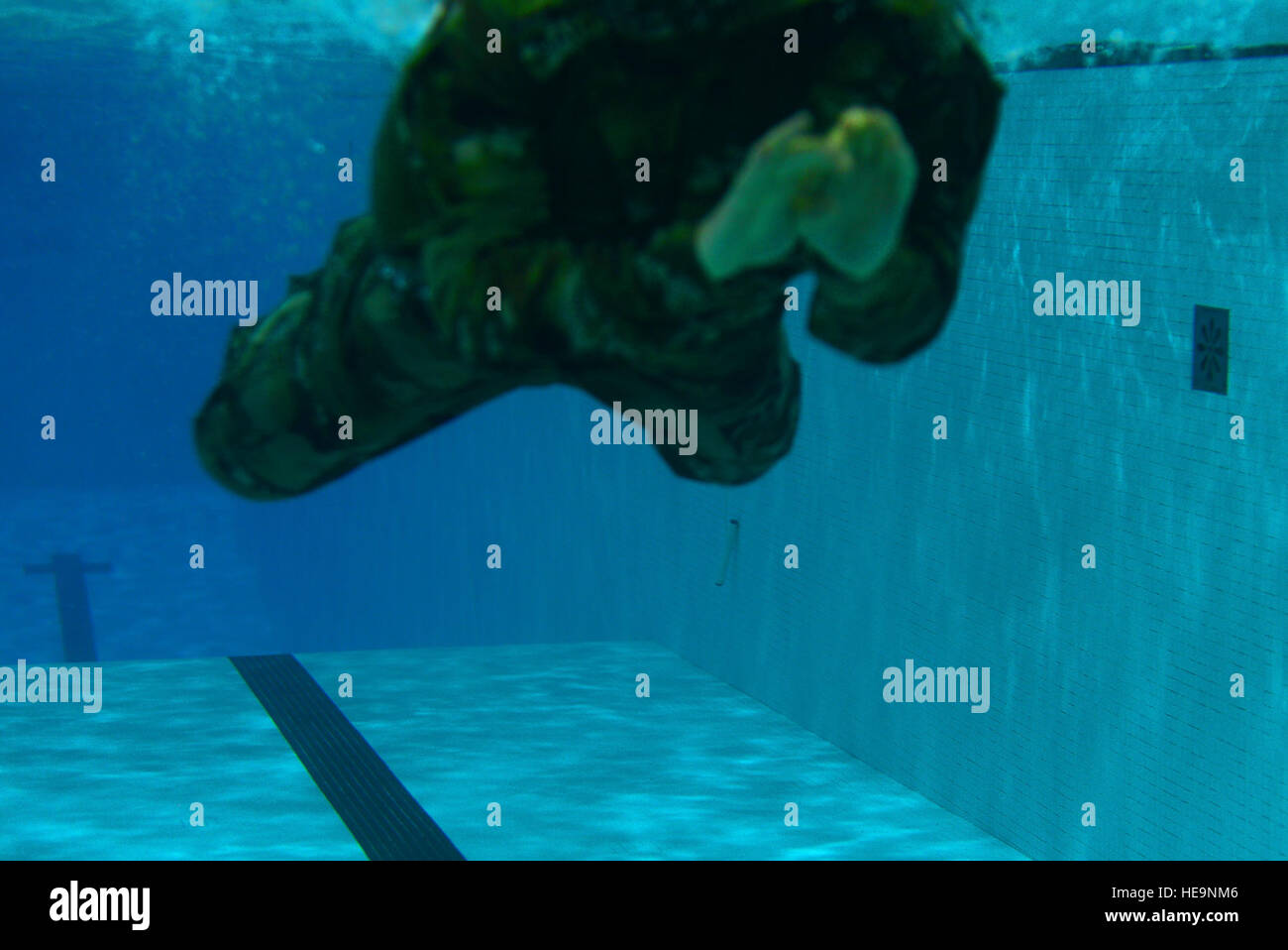 An U.S. Army Soldier dives into a pool for the 100-meter swim during ...