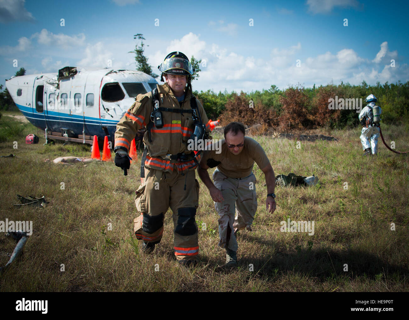 An Eglin Air Force Base firefighter carries a victim to the medical ...