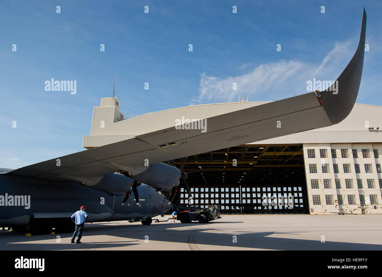 A Lockheed Martin contractor attaches the MC-130J to an aircraft tow ...
