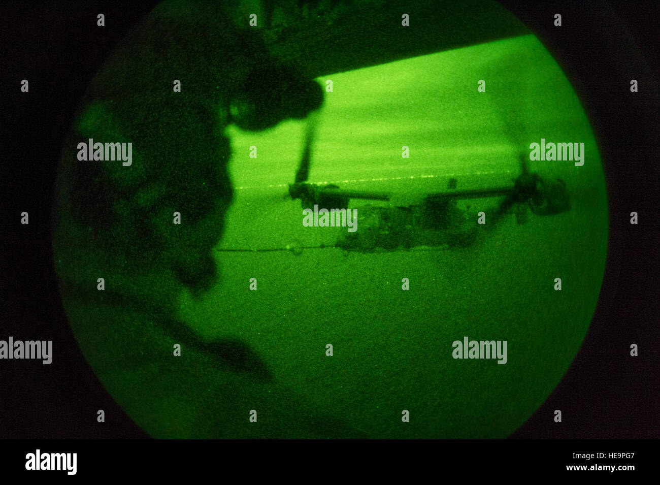 A U.S. Air Force loadmaster watches a CV-22 Osprey receive fuel from an ...