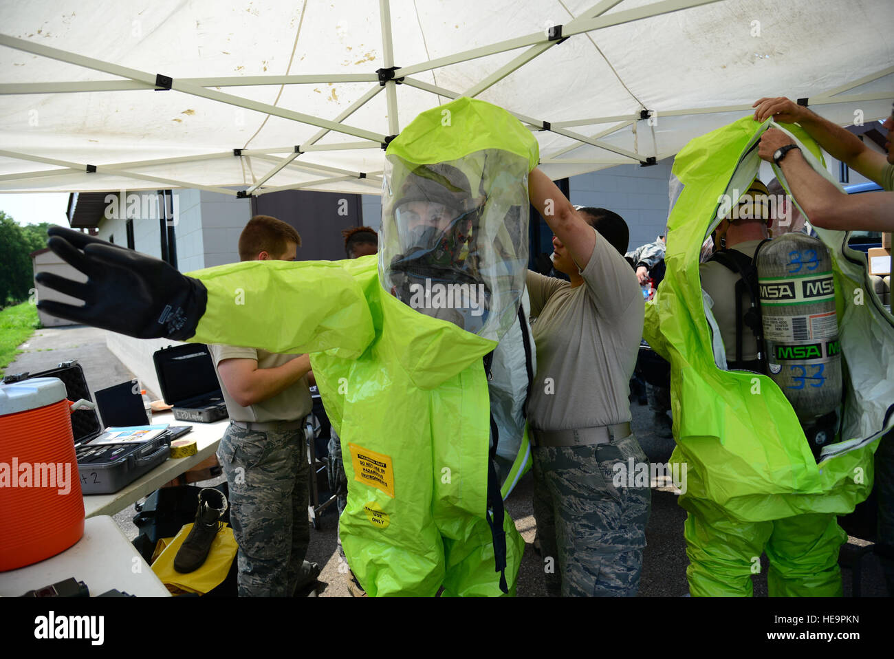 Airmen don level A CBRN protective suits during a base emergency ...