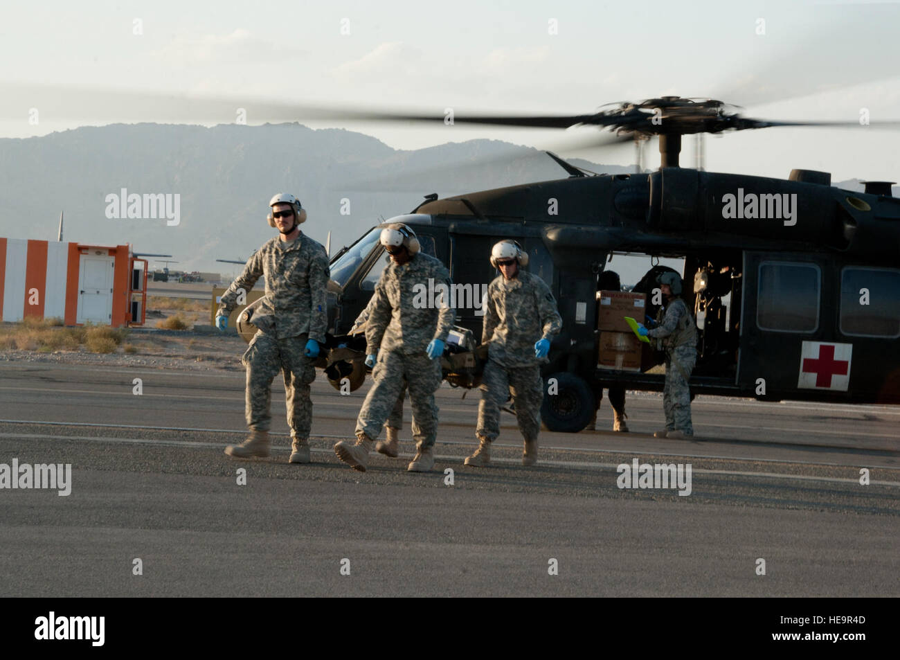 Members of the litter team carry in equipment from an HH-60G Pave Hawk ...