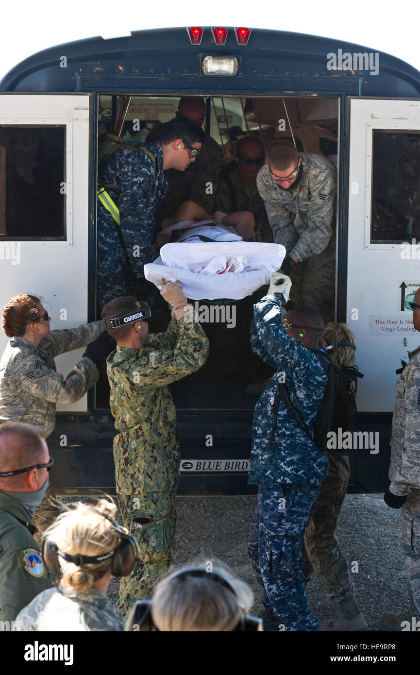 U.S. Airmen, Soldiers and Sailors offload simulated patients from a bus ...