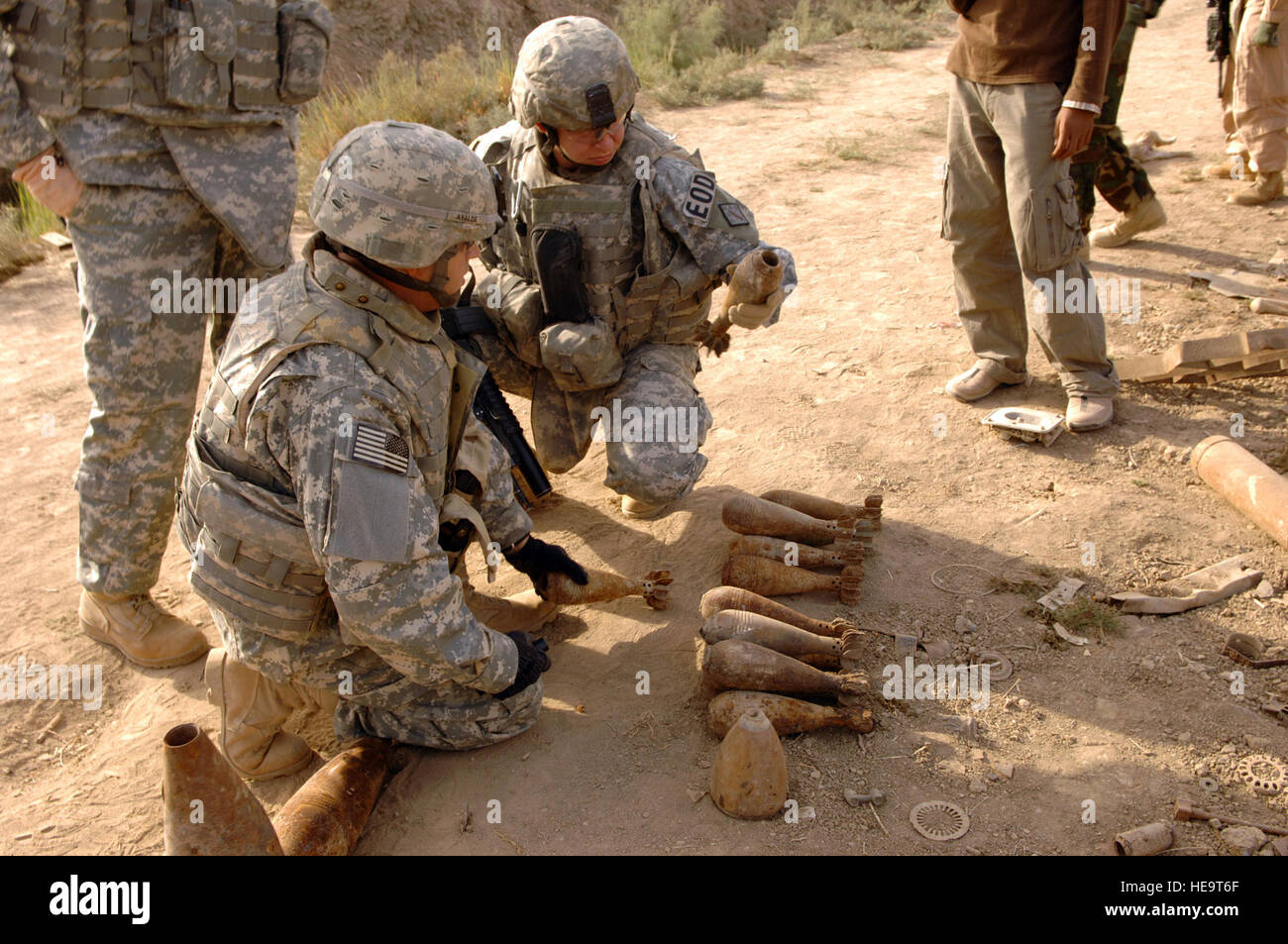 U.S. Army Explosive Ordinance Disposal personnel from Camp Taji examine ...