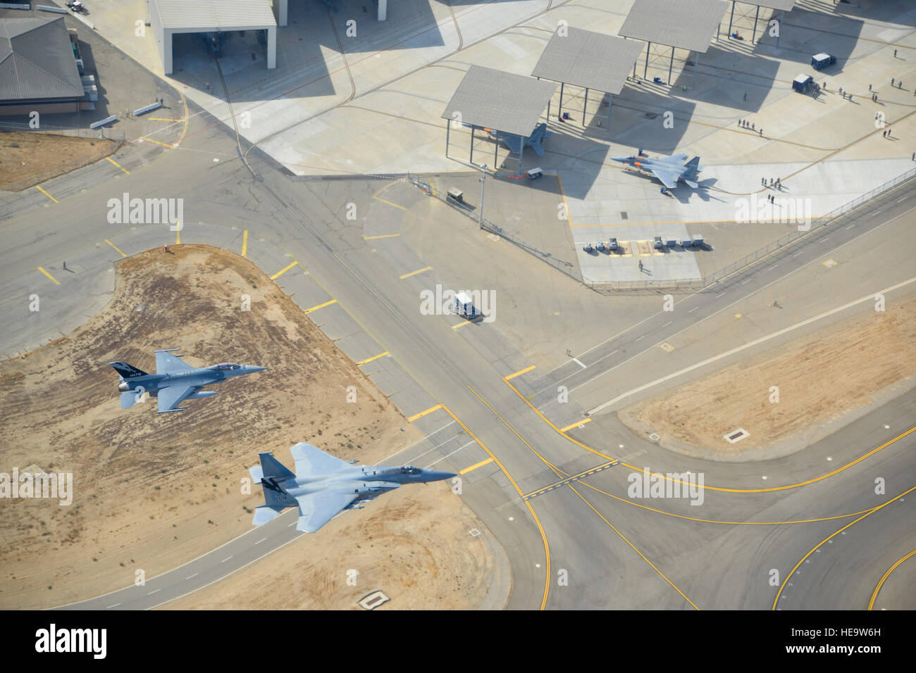 A U.S. Air Force F-15 Eagle and an F-16C Fighting Falcon fly over the ...