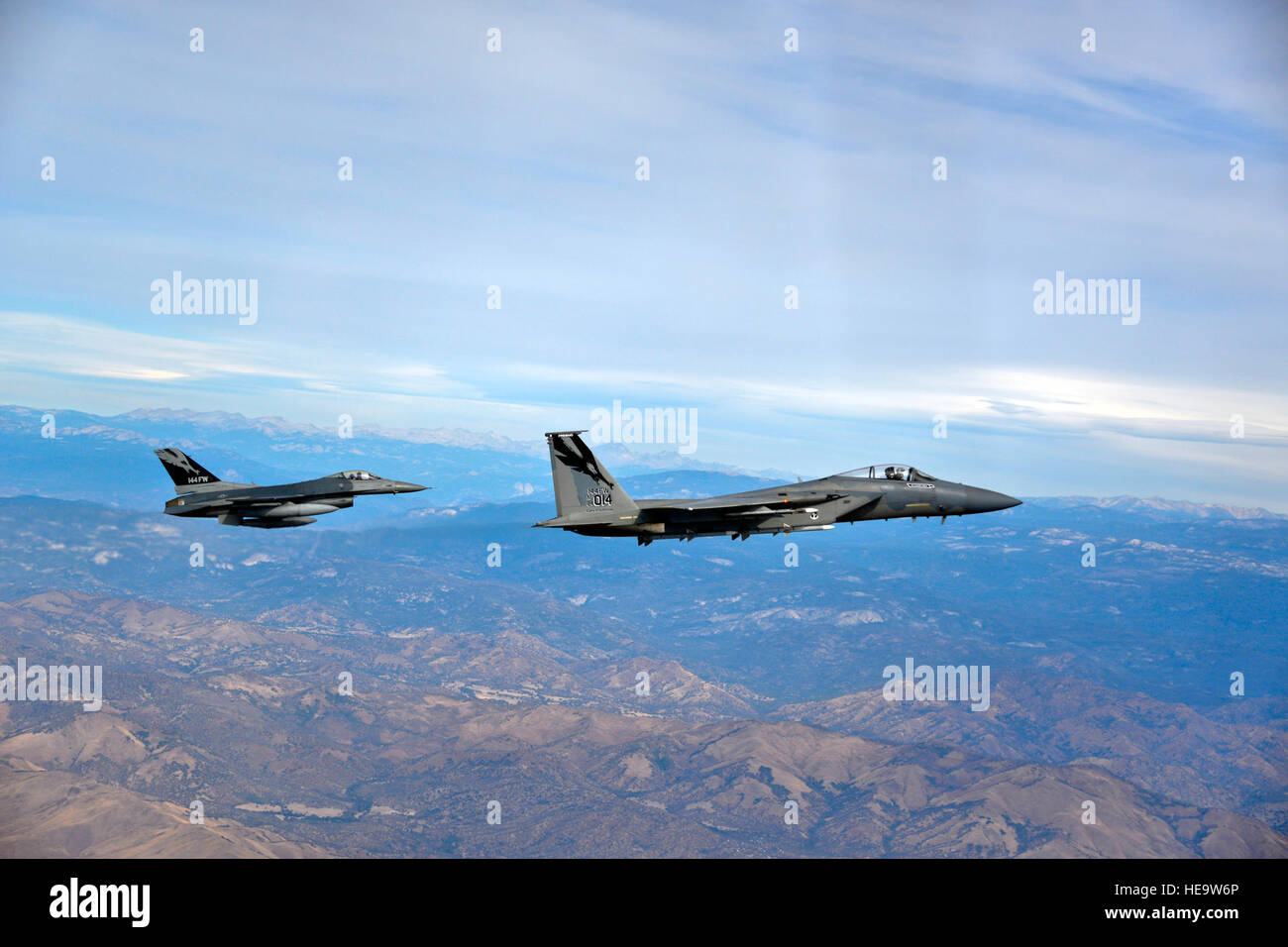 A U.S. Air Force F-15 Eagle and an F-16C Fighting Falcon fly over the ...