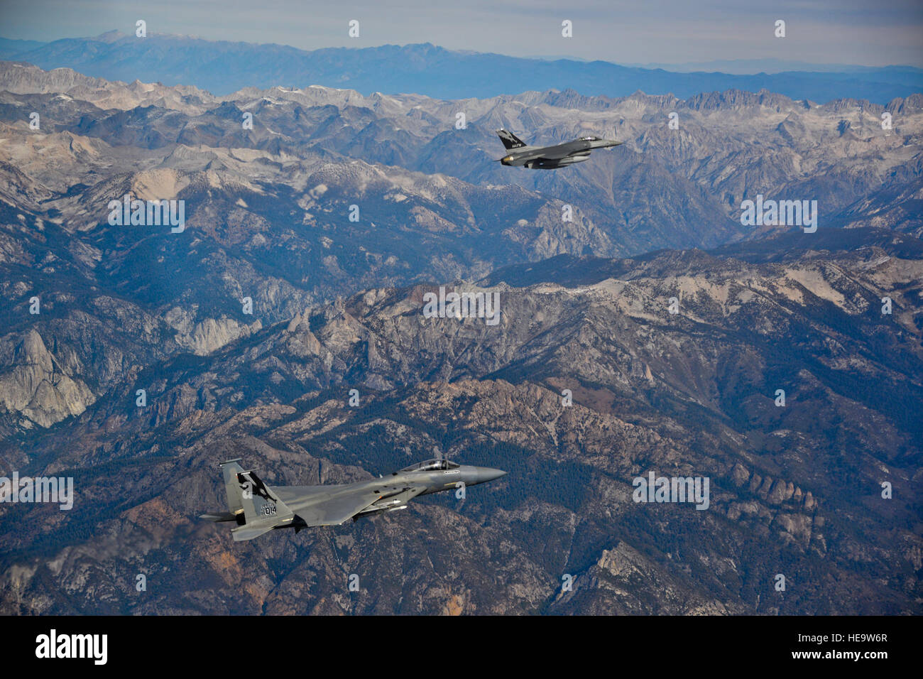 A U.S. Air Force F-15 Eagle and an F-16C Fighting Falcon fly over the ...