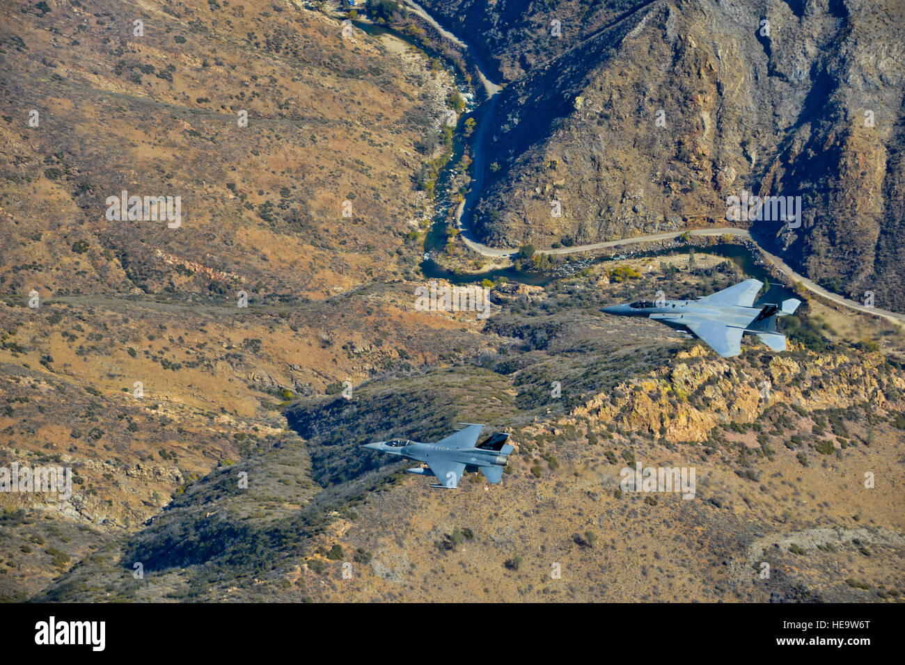 A U.S. Air Force F-15 Eagle and an F-16C Fighting Falcon fly over the ...