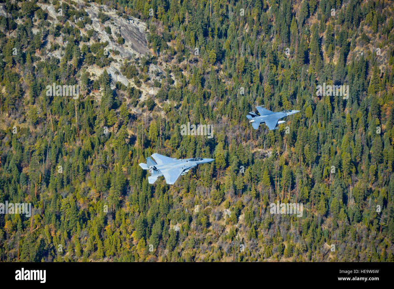 A U.S. Air Force F-15 Eagle and an F-16C Fighting Falcon fly over the ...