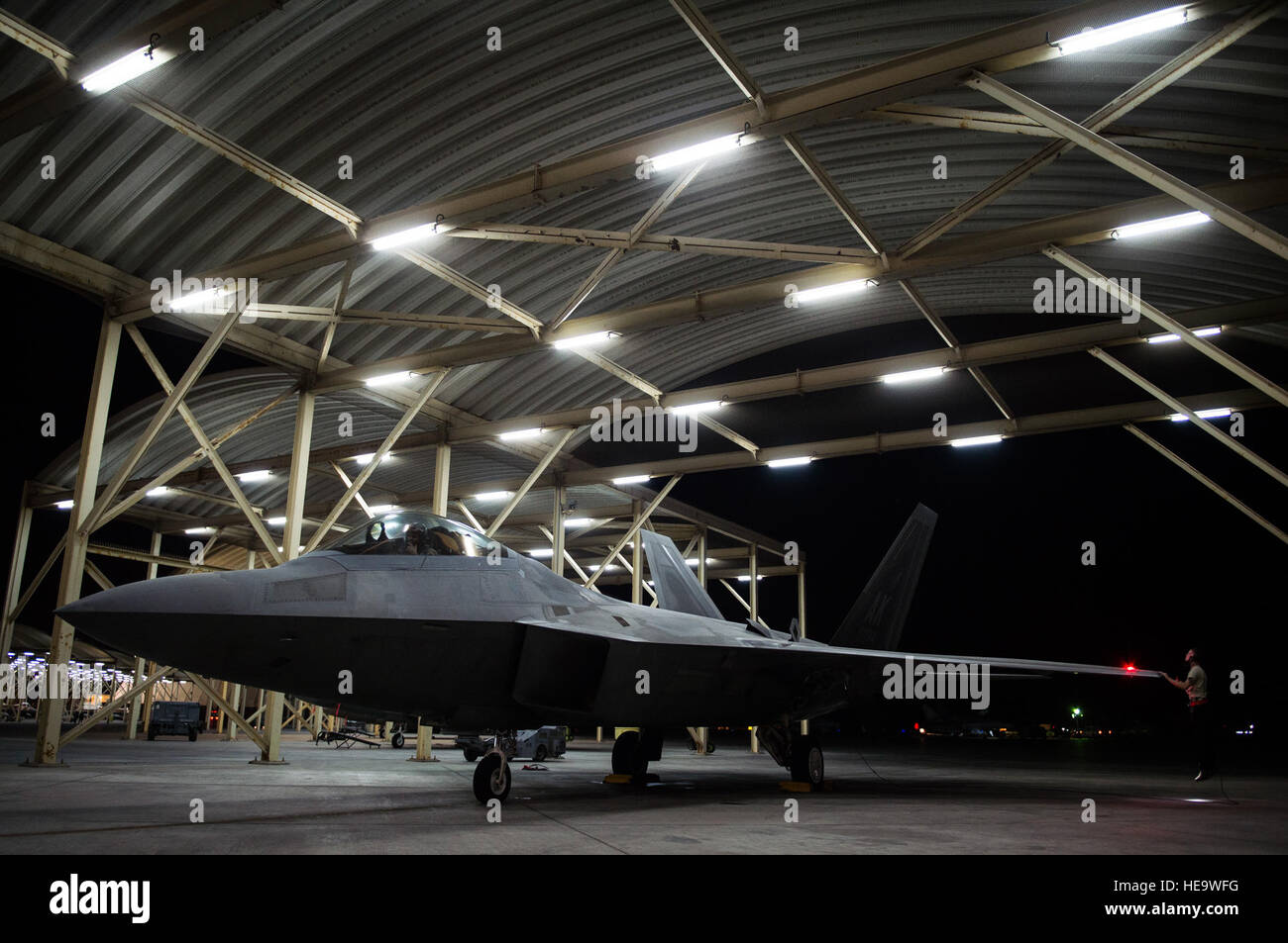 A U.S. Air Force F-22 Raptor crew chief (right), inspects the left wing ...