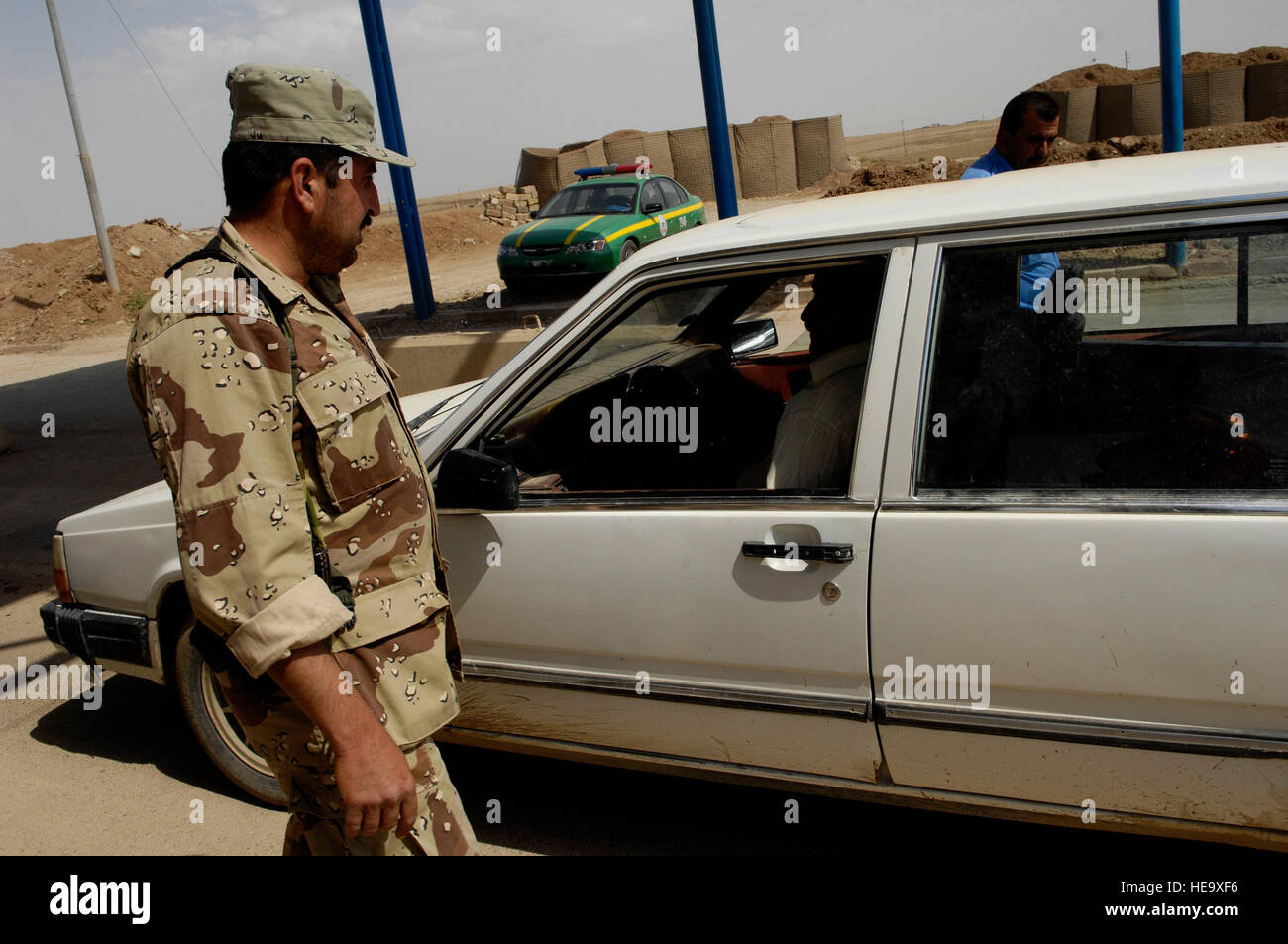 An Iraqi soldier, left, and an Iraqi police officer, far right, stop a ...