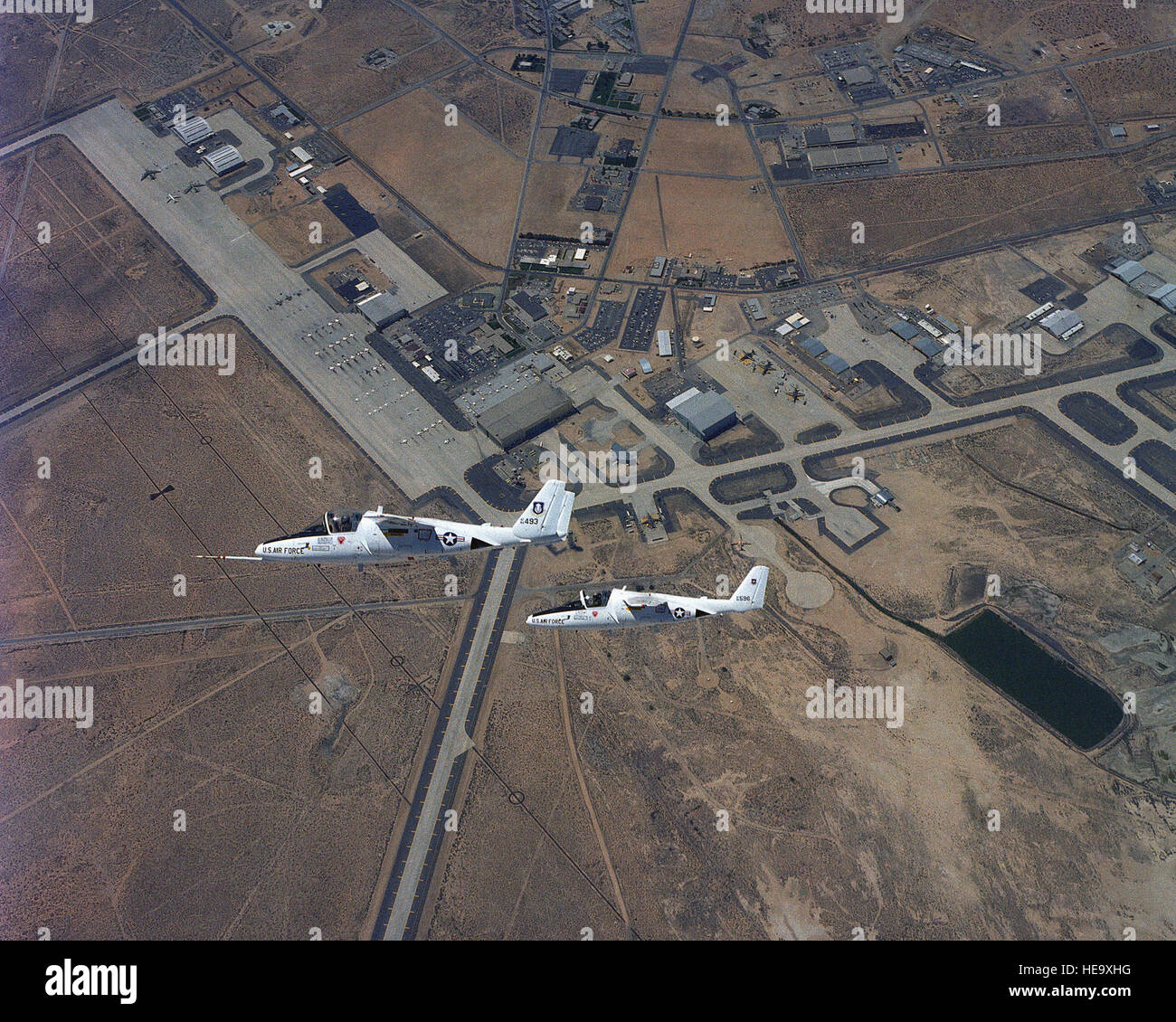 An air-to-air left side view of two T-46 aircraft circling the base ...