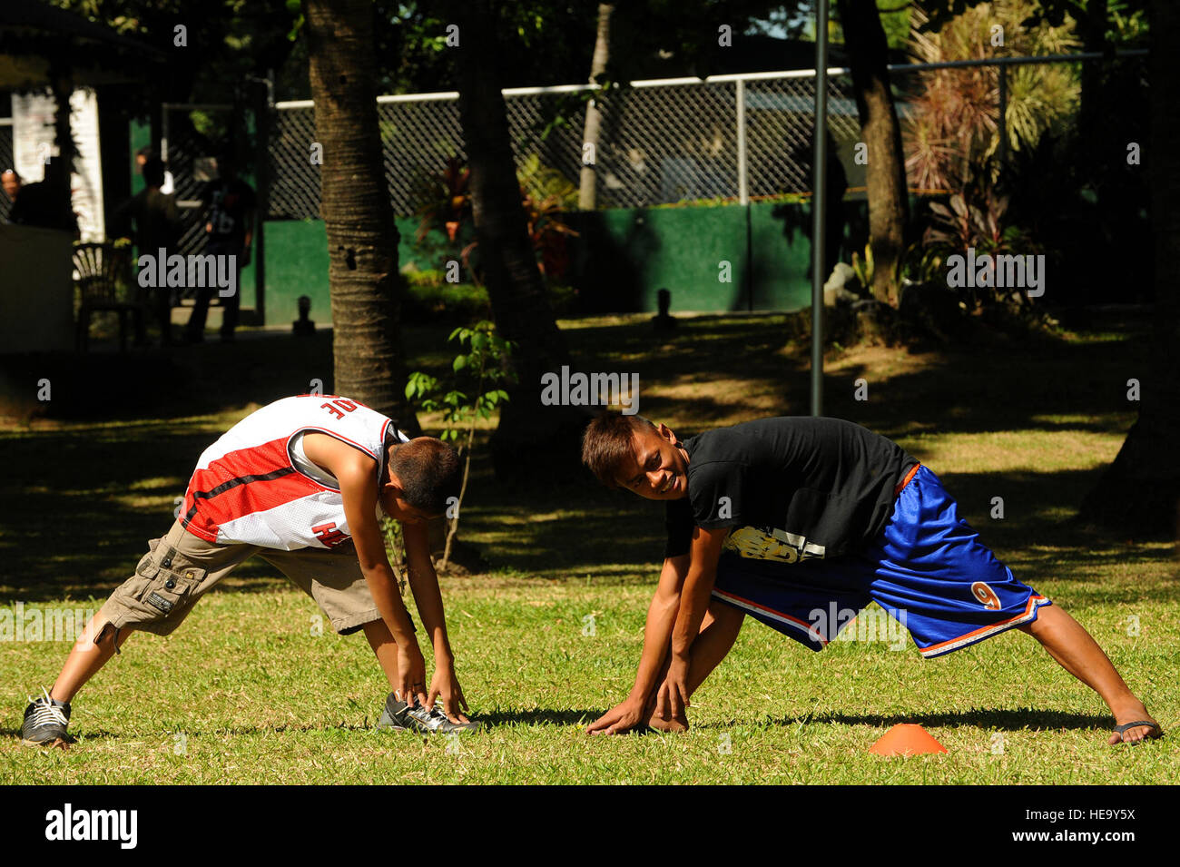 Filipino boys are shown how to avoid injuries by stretching during a ...