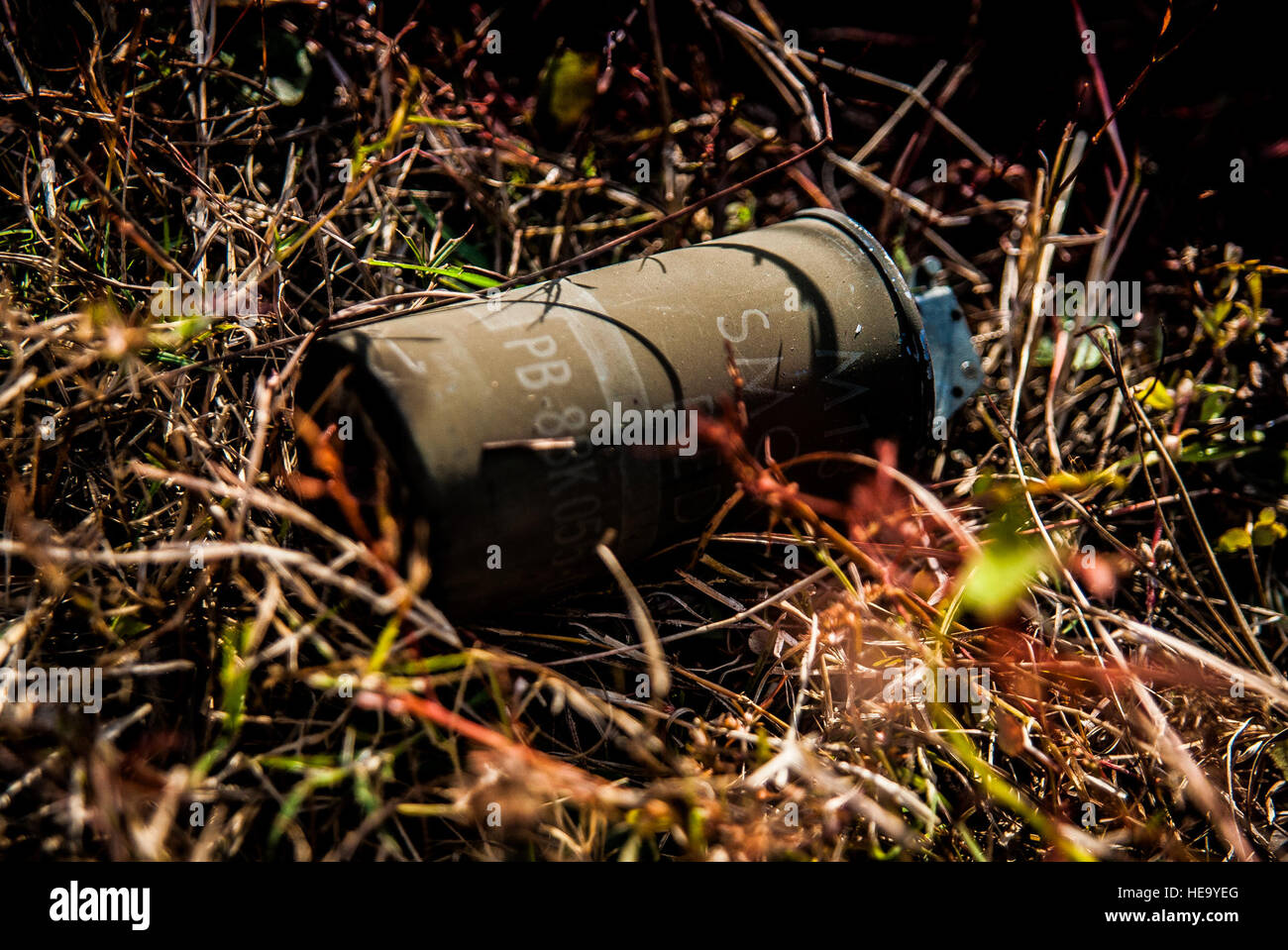 A smoke grenade lies in the grass after being thrown into a ditch ...