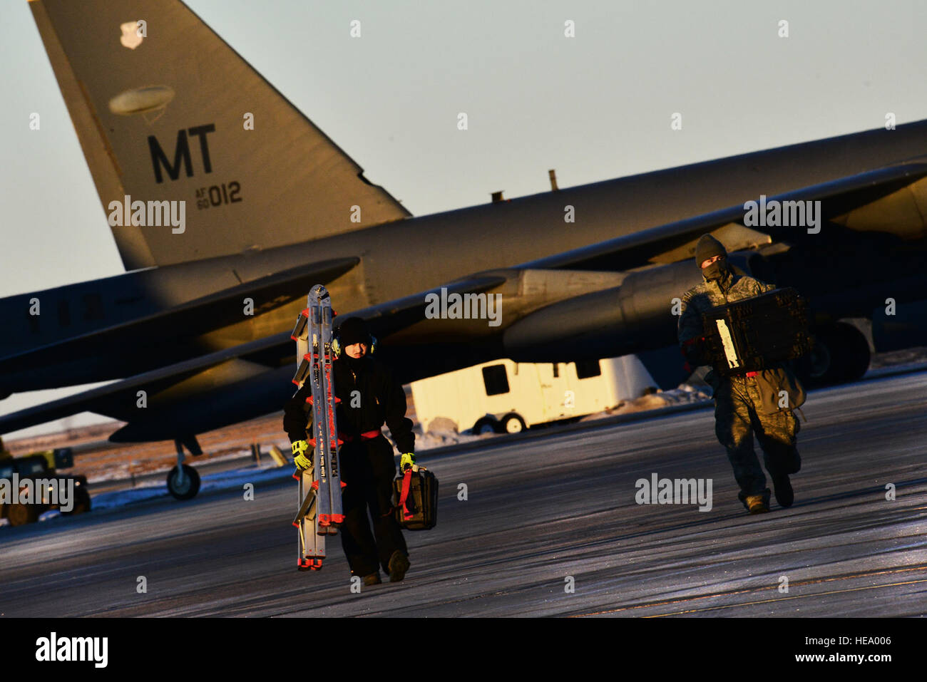 Airmen from the 5th Maintenance Group carry equipment on the flightline ...