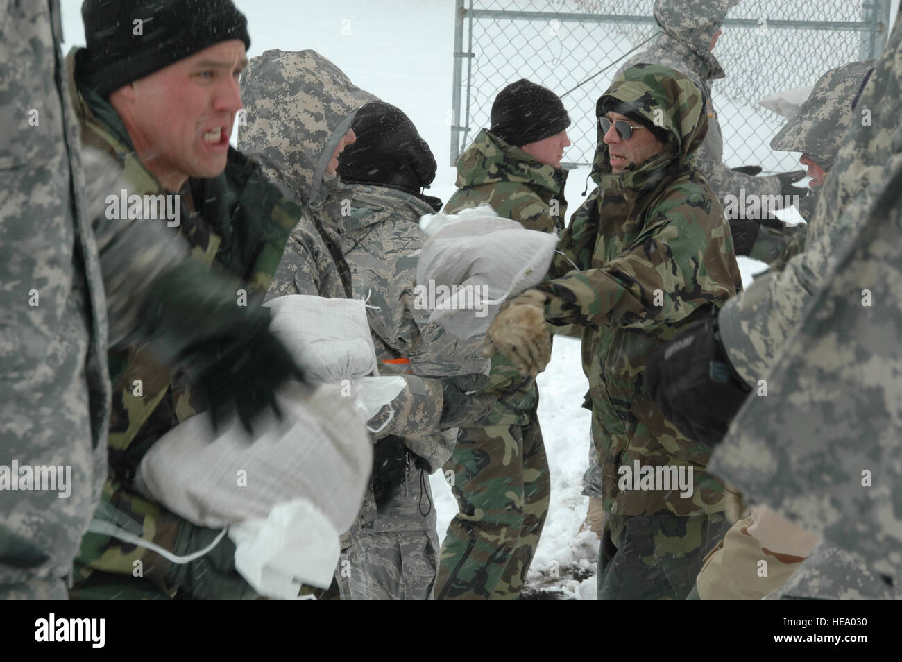 Soldiers and Airmen of the North Dakota National Guard pass sandbags ...