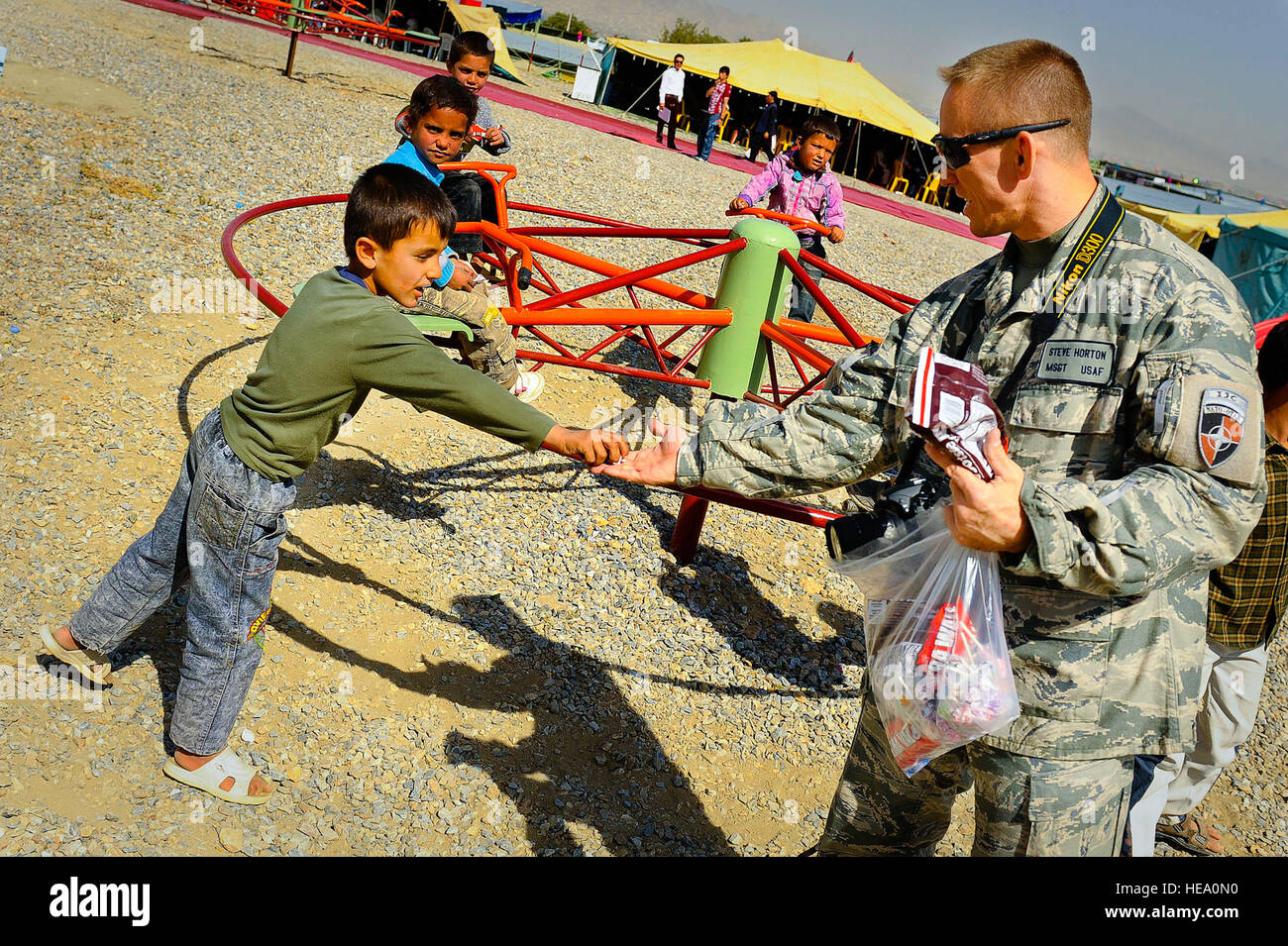 U.S. Air Force Master Sgt. Steve Horton, ISAF Joint Command, hands out ...