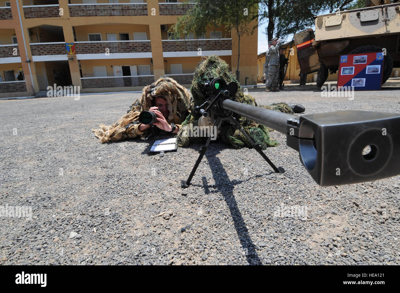 U.S. Master Sgt Travis Lemon (left) looks through a spotting scope as a ...