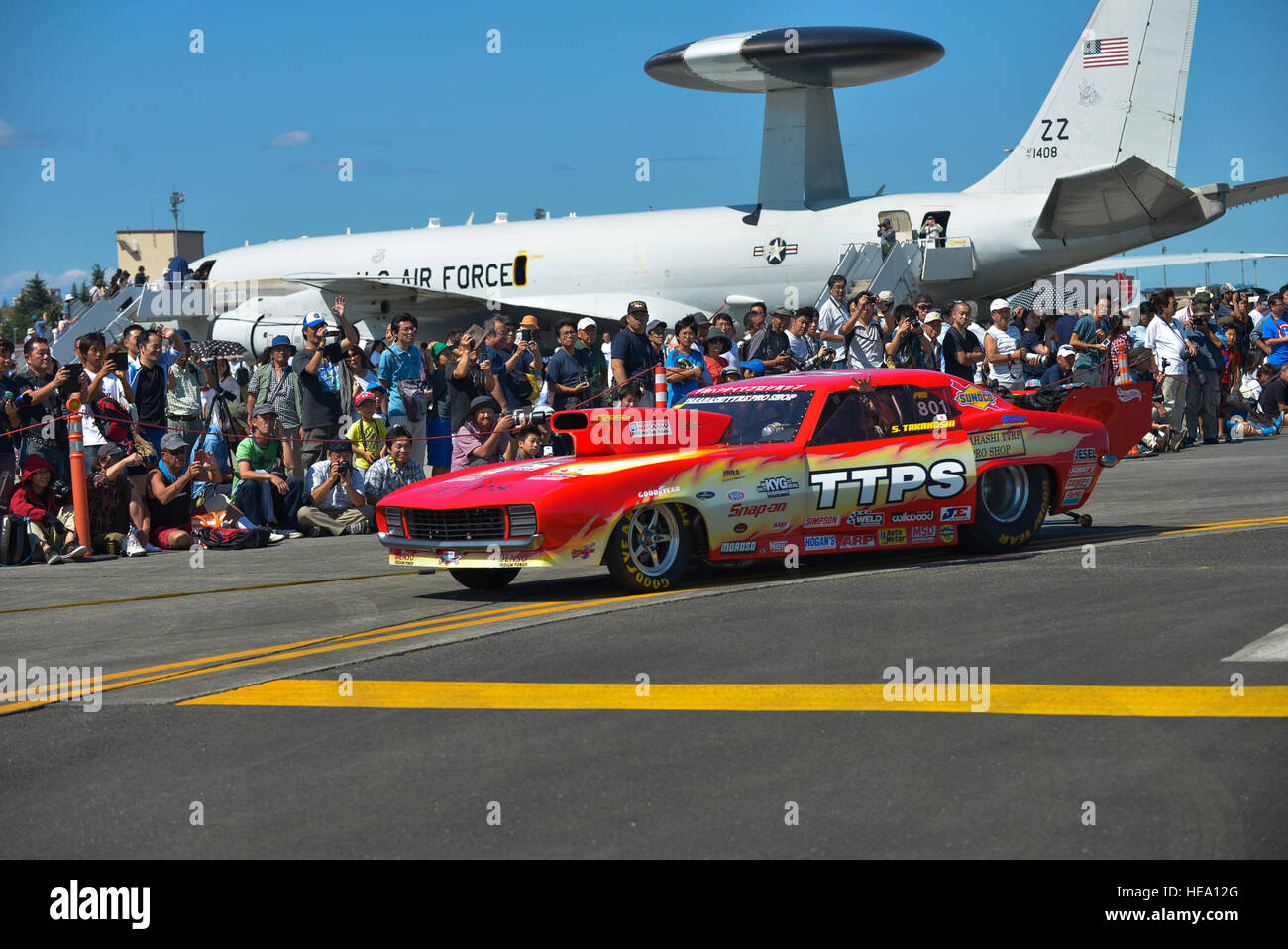 A drag race vehicle is taken past a crowd of spectators after driving ...