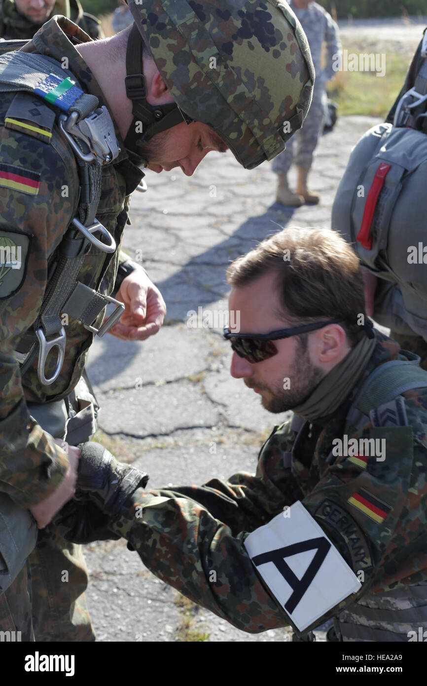 German Paratrooper Sgt. First Class Julian Koch. assists Lt. Daniel Knopp both assigned to the ...
