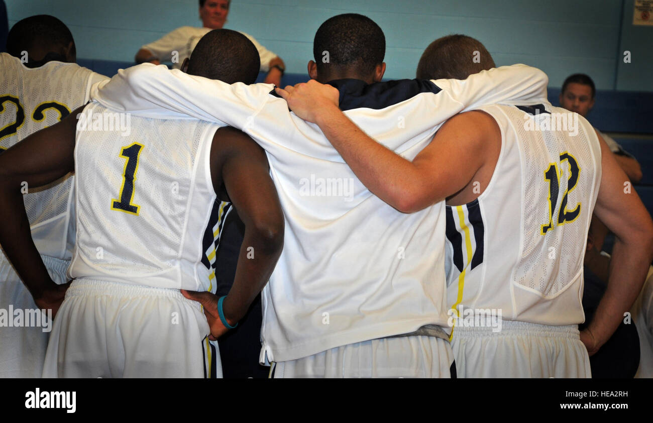 All-Navy basketball team members lean on each other during a time out ...