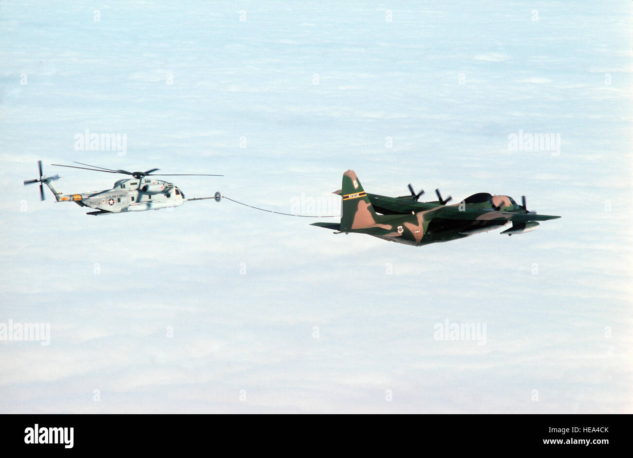 An air-to-air left side view of HC-130 Hercules aircraft refueling a ...