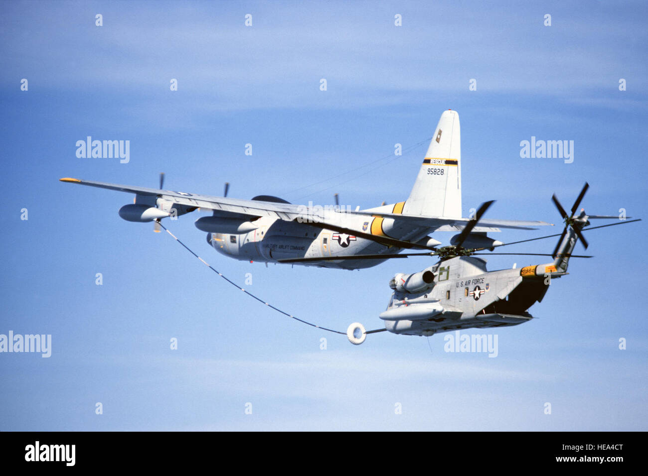An air-to-air left side view of an HC-130 Hercules aircraft refueling a ...