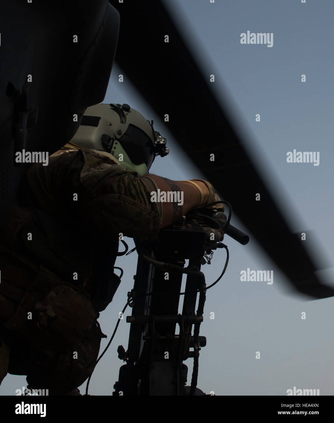 An aerial gunner with the 303rd Expeditionary Rescue Squadron looks out ...