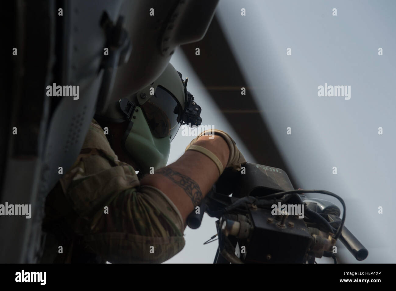 An aerial gunner with the 303rd Expeditionary Rescue Squadron looks out ...