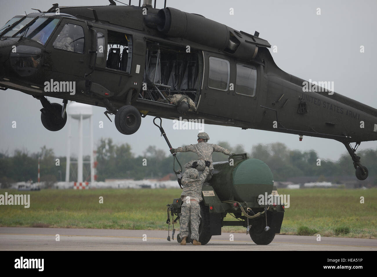 Soldiers attach a water buffalo to a UH-60 Black Hawk helicopter during ...