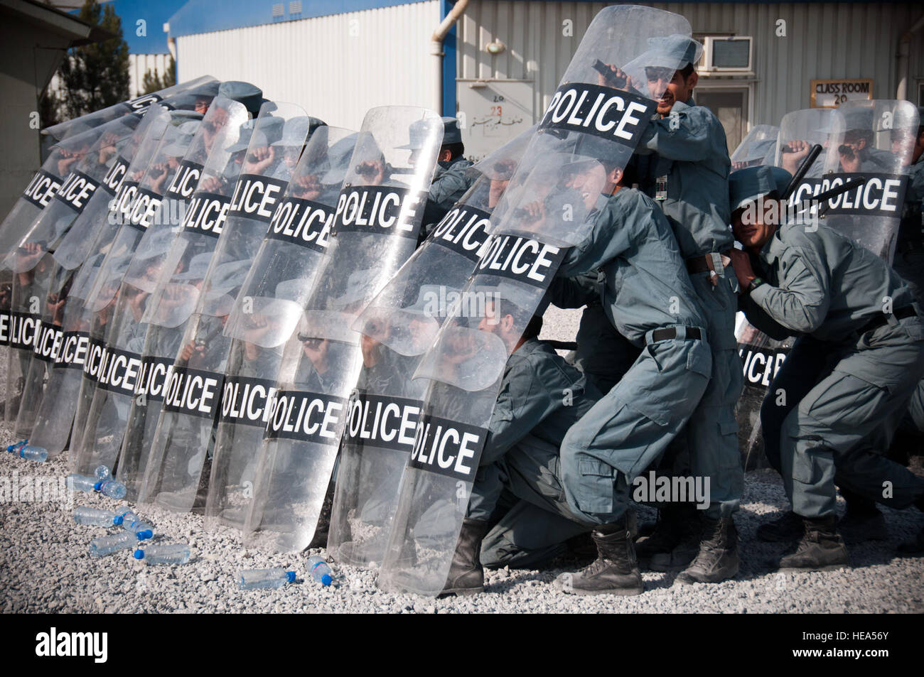 Afghan National Civil Order Police recruits run through a riot control ...