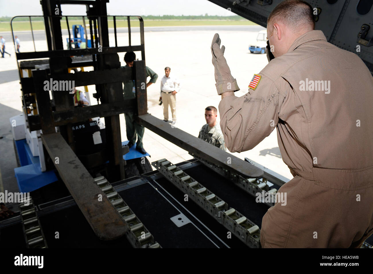A U.S. Air Force loadmaster and Pakistani ground crew personnel unload ...