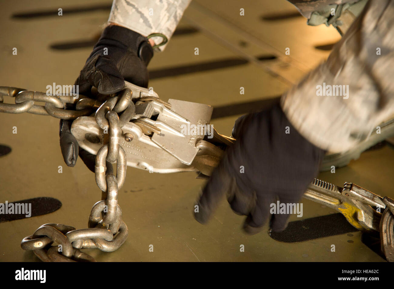 A U.S. Air Force Airman chains down a Southern California Edison truck ...
