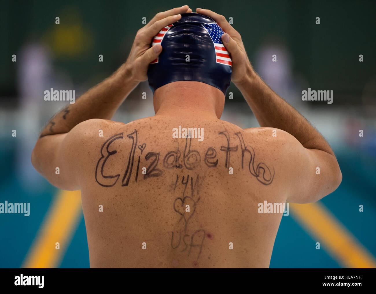 Retired U.S. Naval Aircrewman Brett Parks fixes his swimming cap before ...