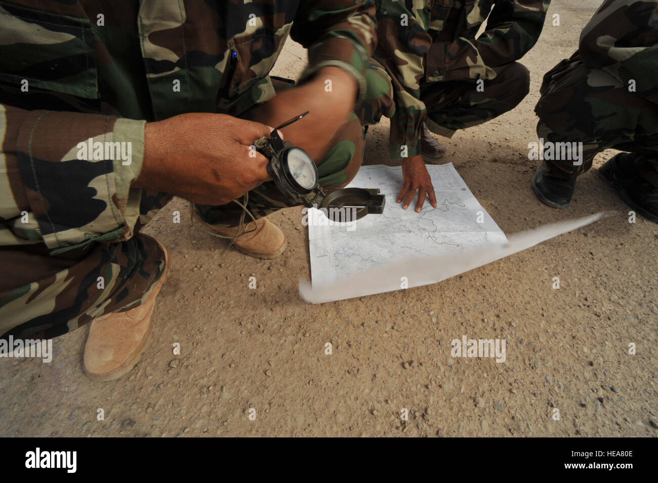 Iraqi air force airmen use a map and compass during the land-navigation ...