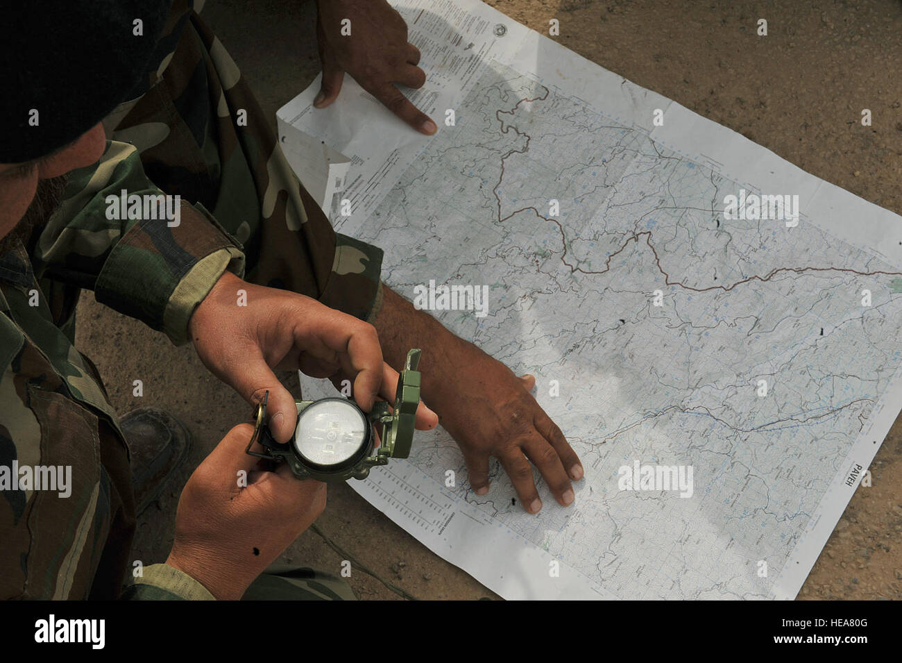 Iraqi air force airmen use a map and compass during the land navigation ...