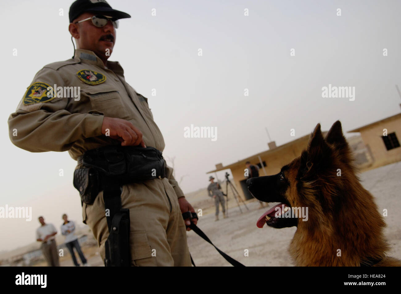 An Iraqi dog handler gives a command to his dog, during a training ...