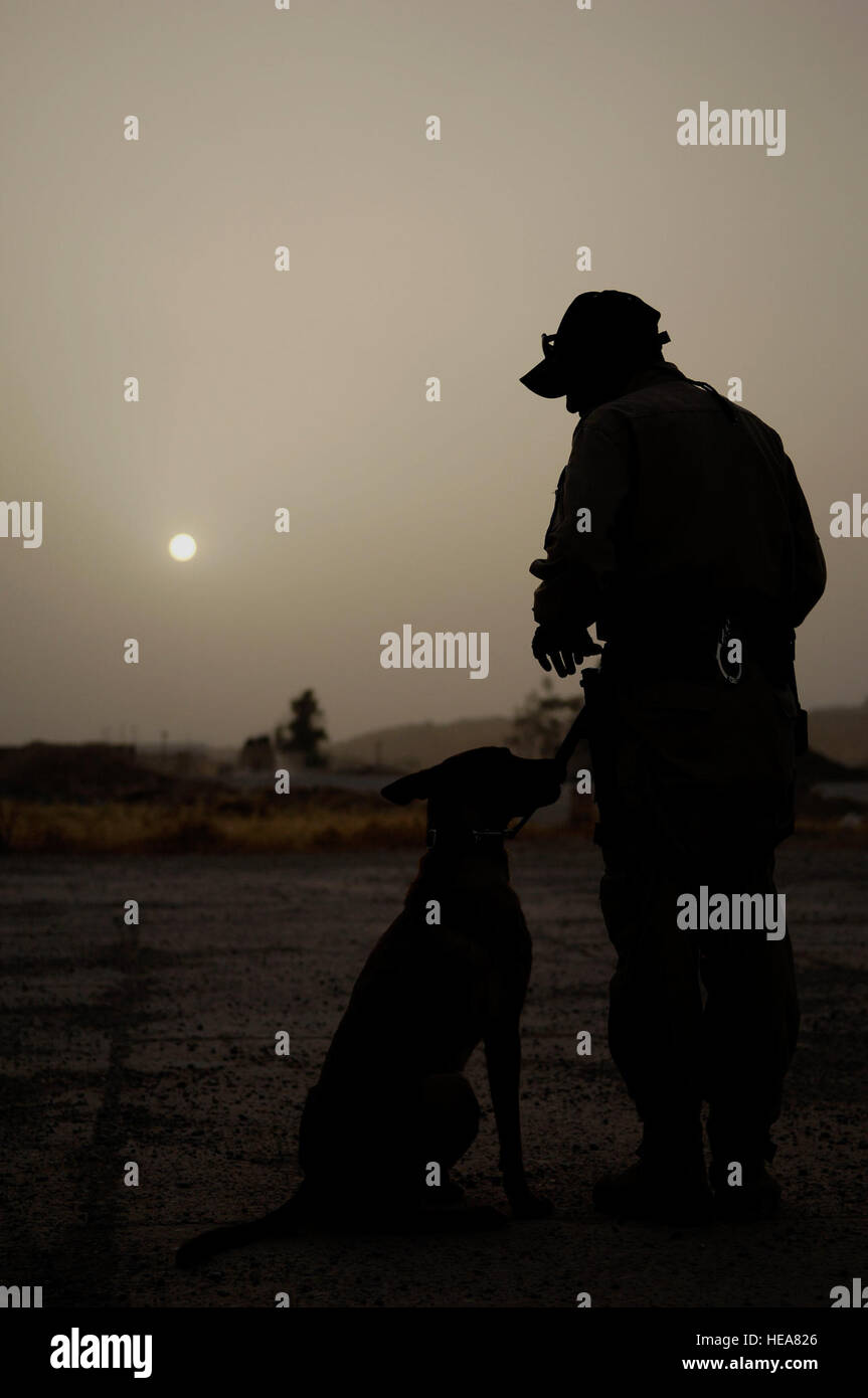An Iraqi dog handler and his dog, Cash, take a break during a training ...