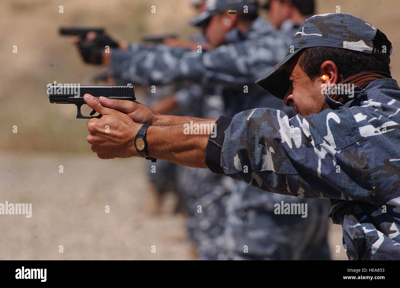 Iraqi police officers shoot their pistols during training at a range on ...