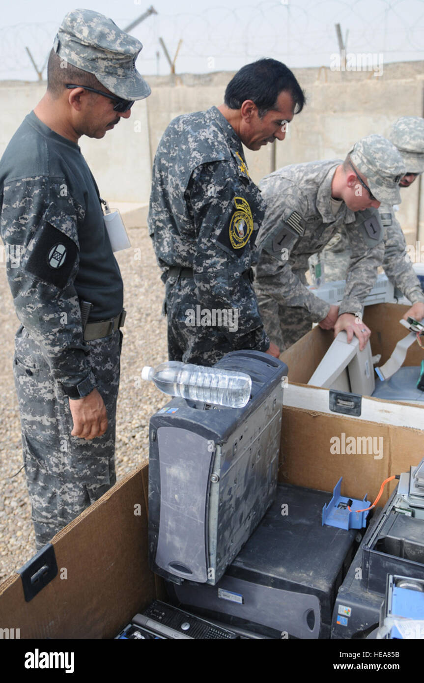 A U.S. Soldier sorts through a box of computers at the Camp Victory ...