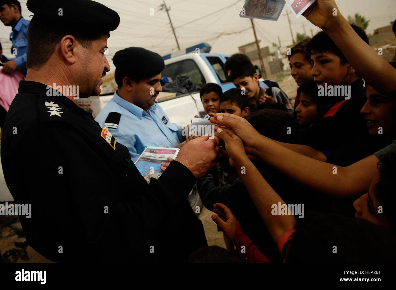 Iraqi police officers hand out leaflets during a humanitarian aid ...