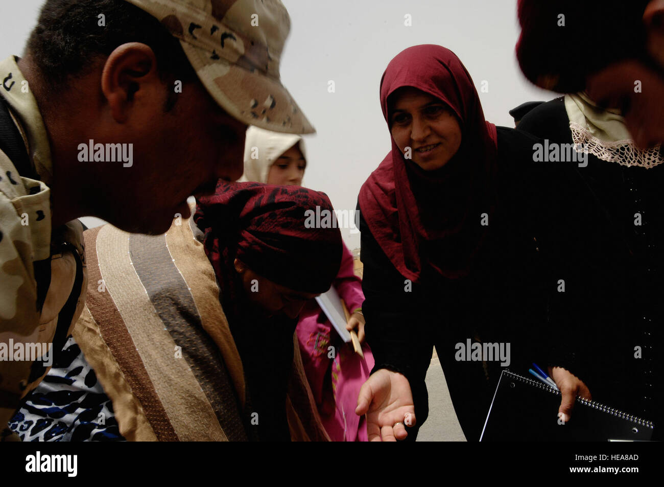 An Iraqi woman requests more school supplies from an Iraqi soldier ...
