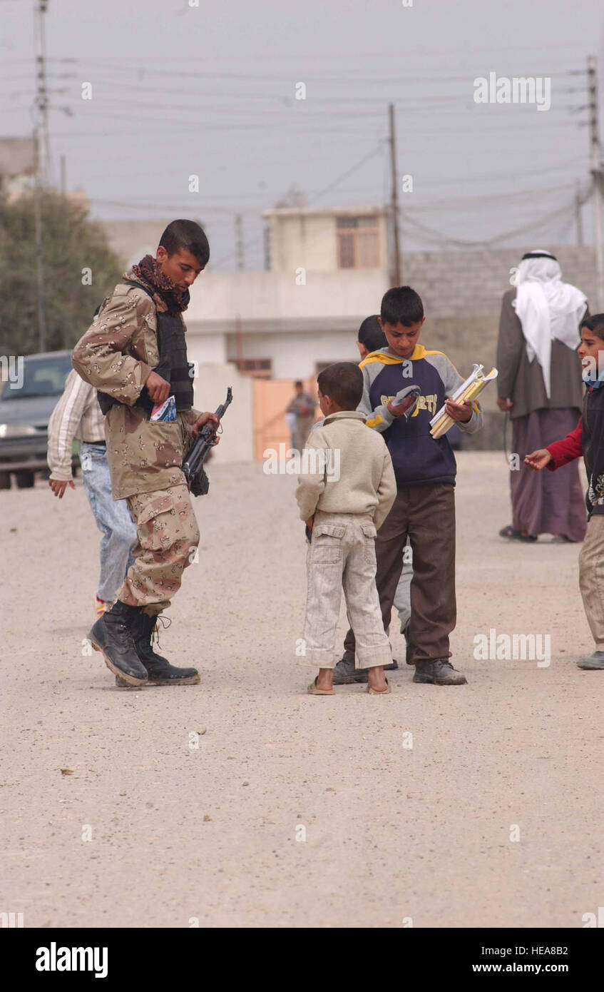 An Iraqi army soldier talks to local children on a patrol with U.S ...