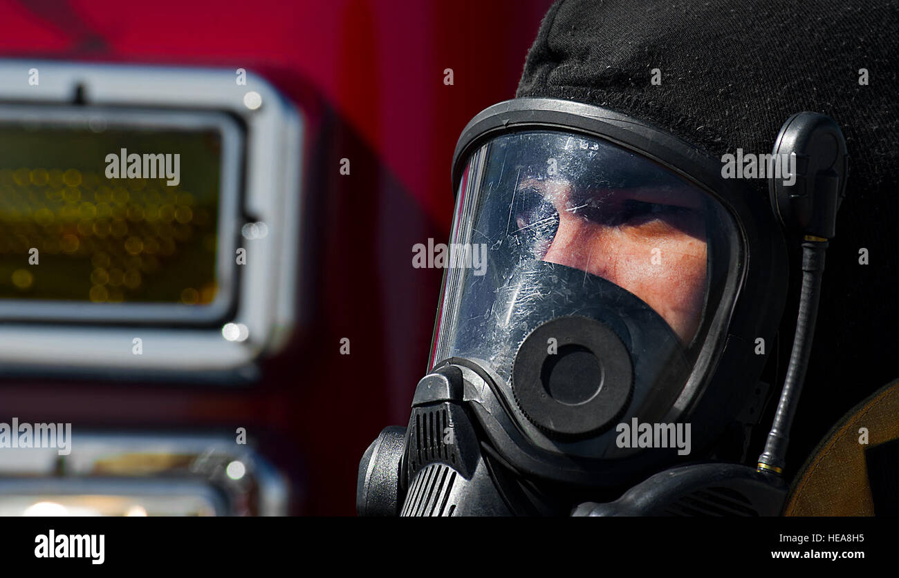 A firefighter from the 5th Civil Engineer Squadron dons his gas mask ...