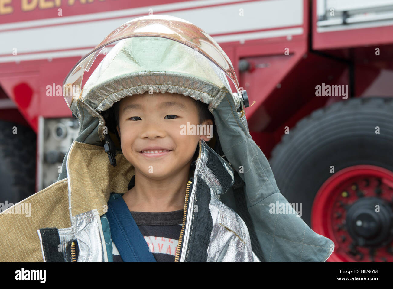 A local boy puts on a firefighting suit for a portrait at Yokota Air ...