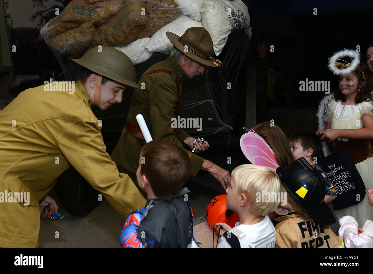 Volunteers and professional reenactors pass out candy to children at ...