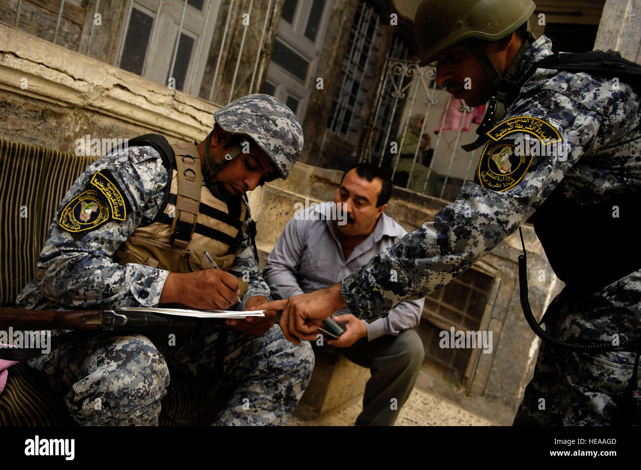 Iraqi police officers talk with an Iraqi man during a joint clearing ...