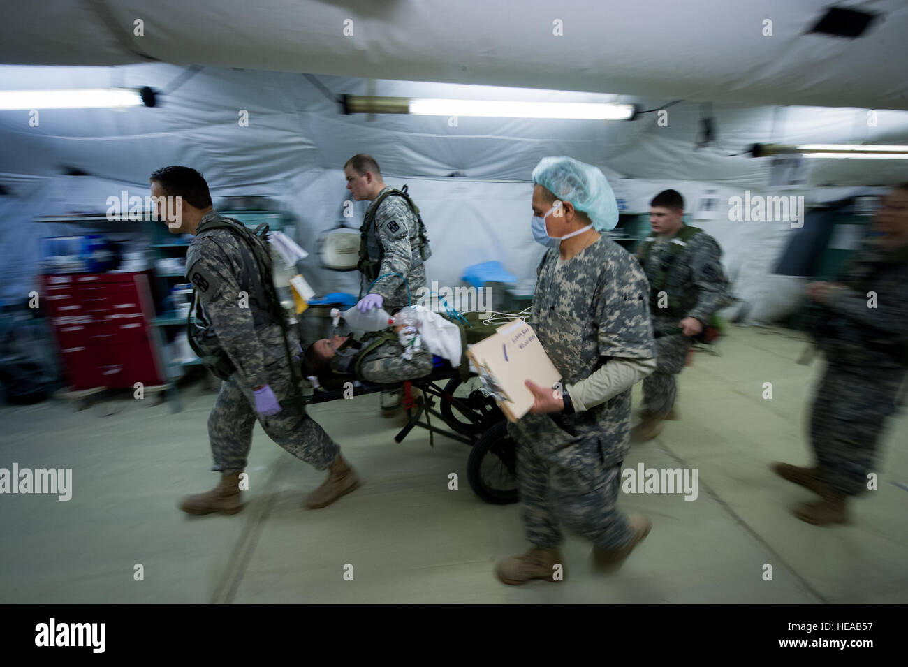 U.S. Army medical personnel rush a simulated injured soldier to surgery ...