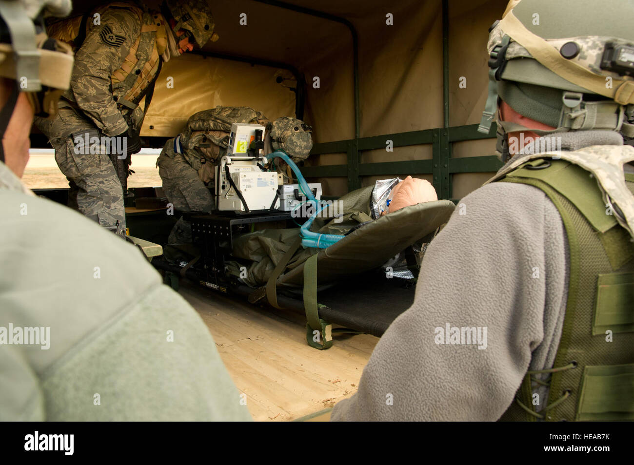 A simulated patient is loaded into the back a Humvee during a field ...