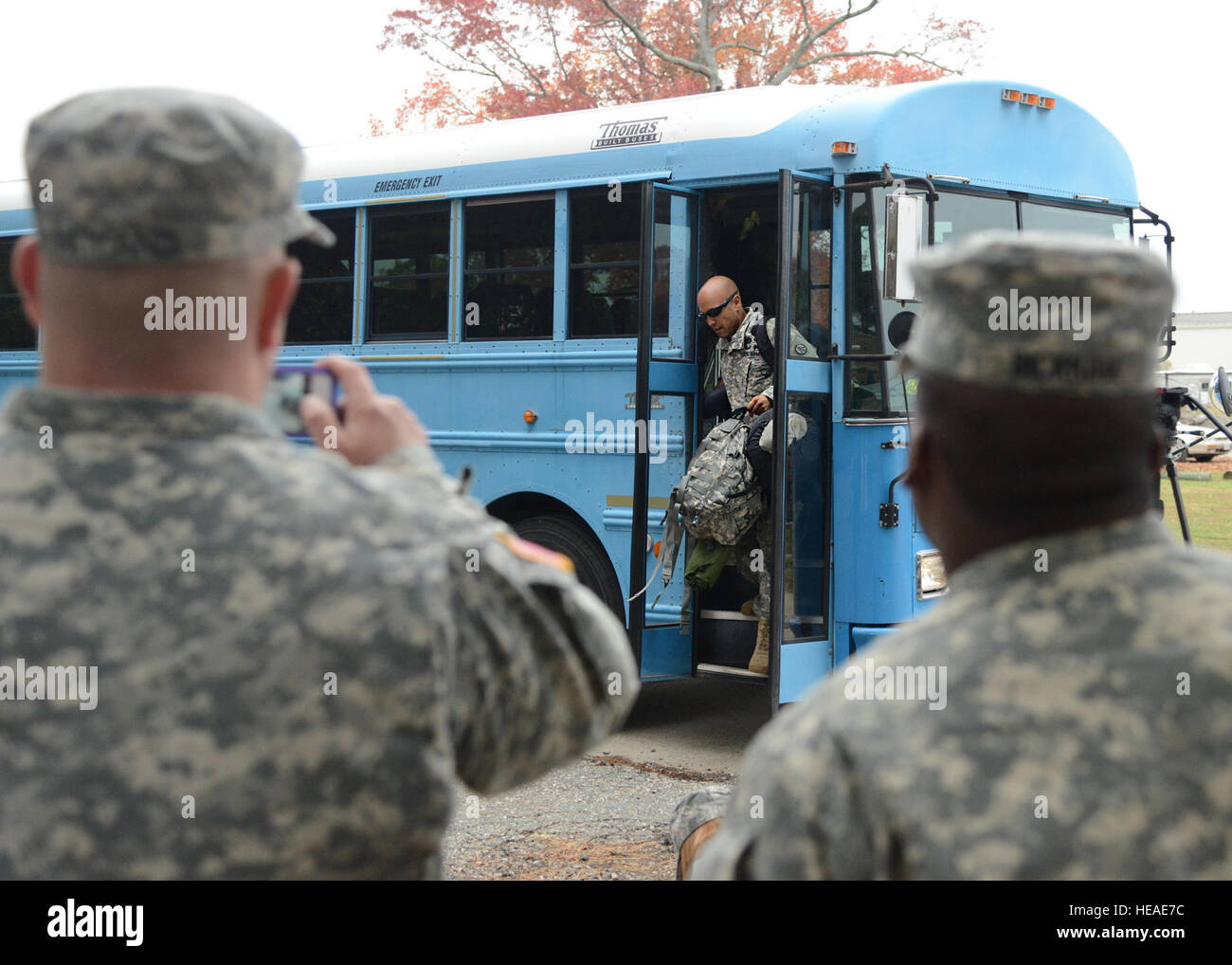 U.S. Army Soldiers look on as service members disembark a bus upon ...